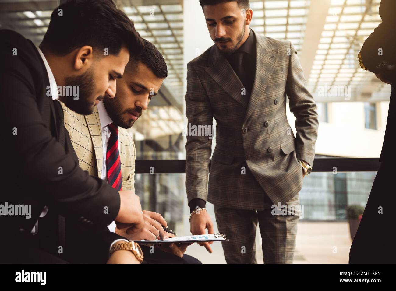 An international team of successful young business men in suits at a ...