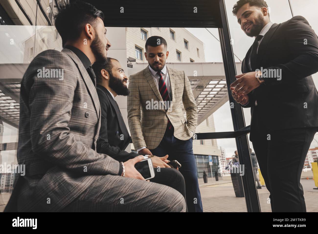 Business people outdoor meeting. Men in jackets discuss working moments ...