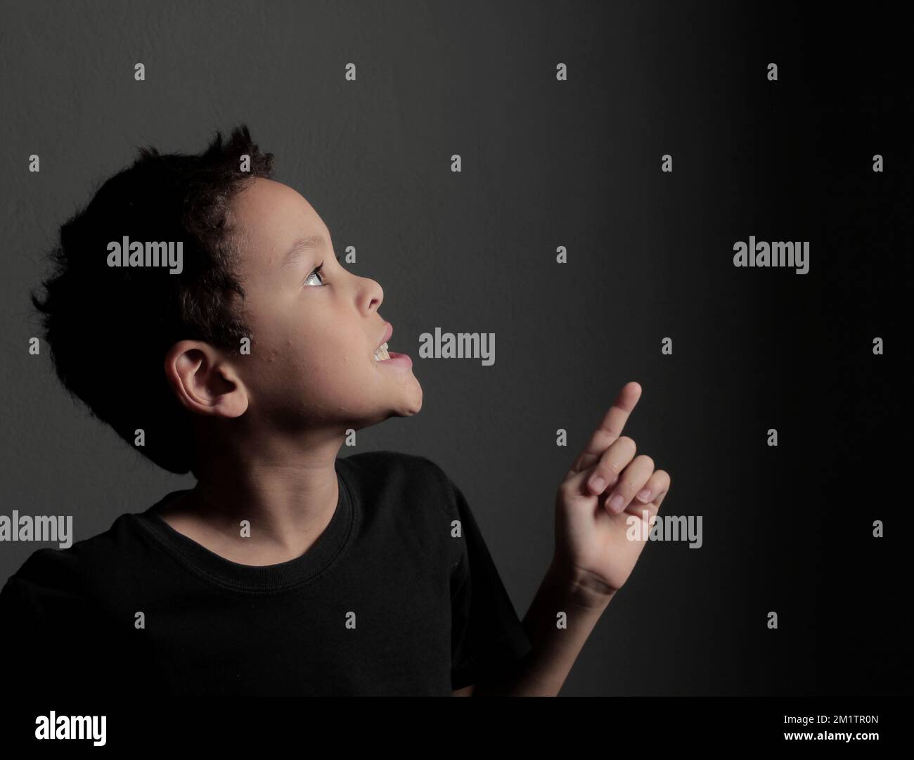 child pointing and reaching up to the sky on white background with ...