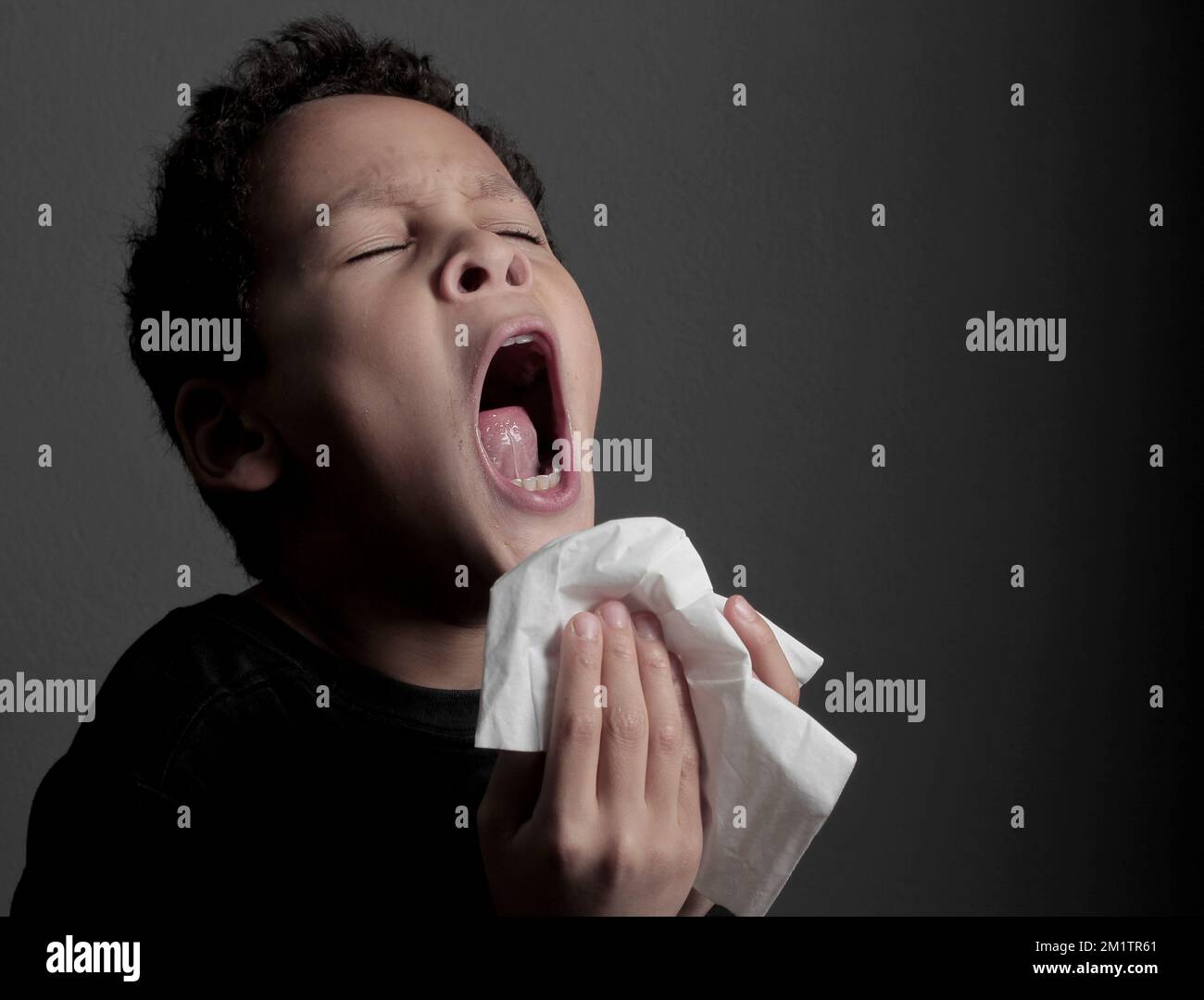 catching the flu child blowing nose after catching a cold with grey ...