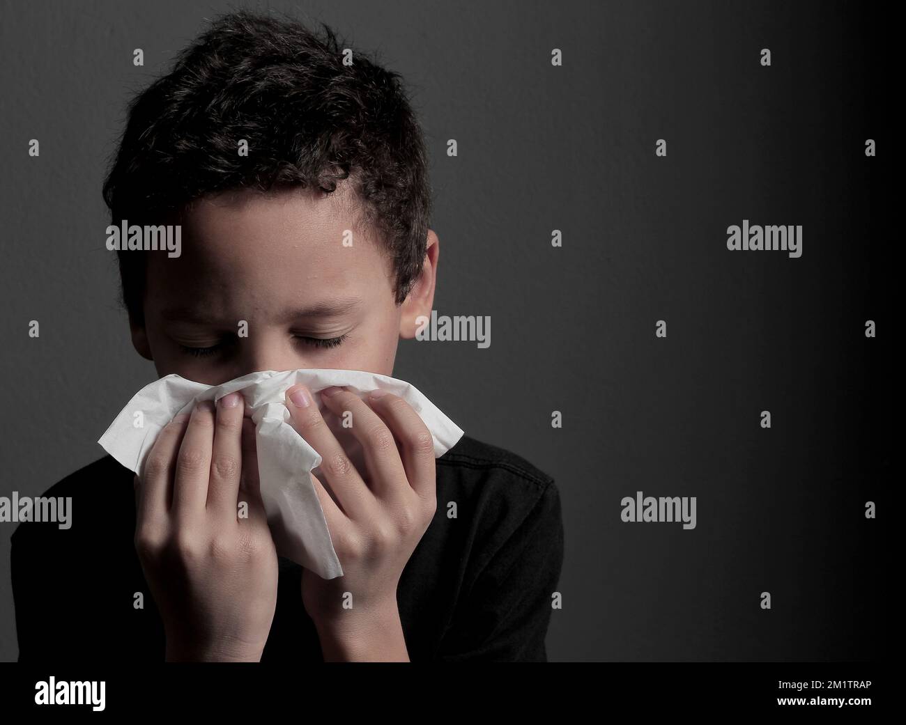 catching the flu child blowing nose after catching a cold with grey ...