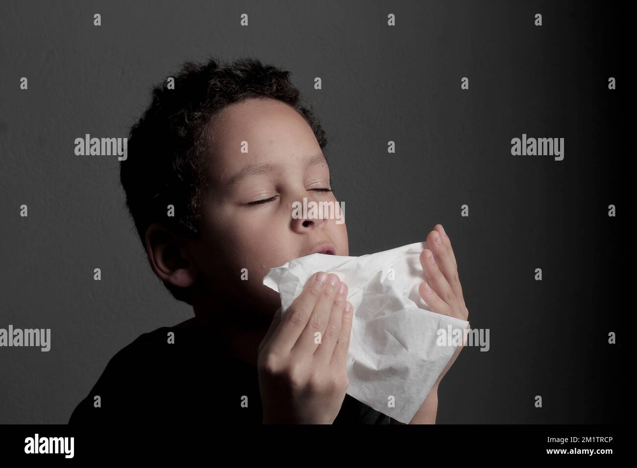 catching the flu child blowing nose after catching a cold with grey ...