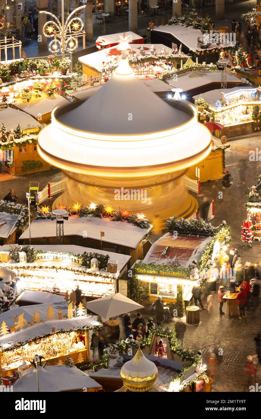 Dresden, Germany. 13th Dec, 2022. A carousel turns next to snow-covered ...