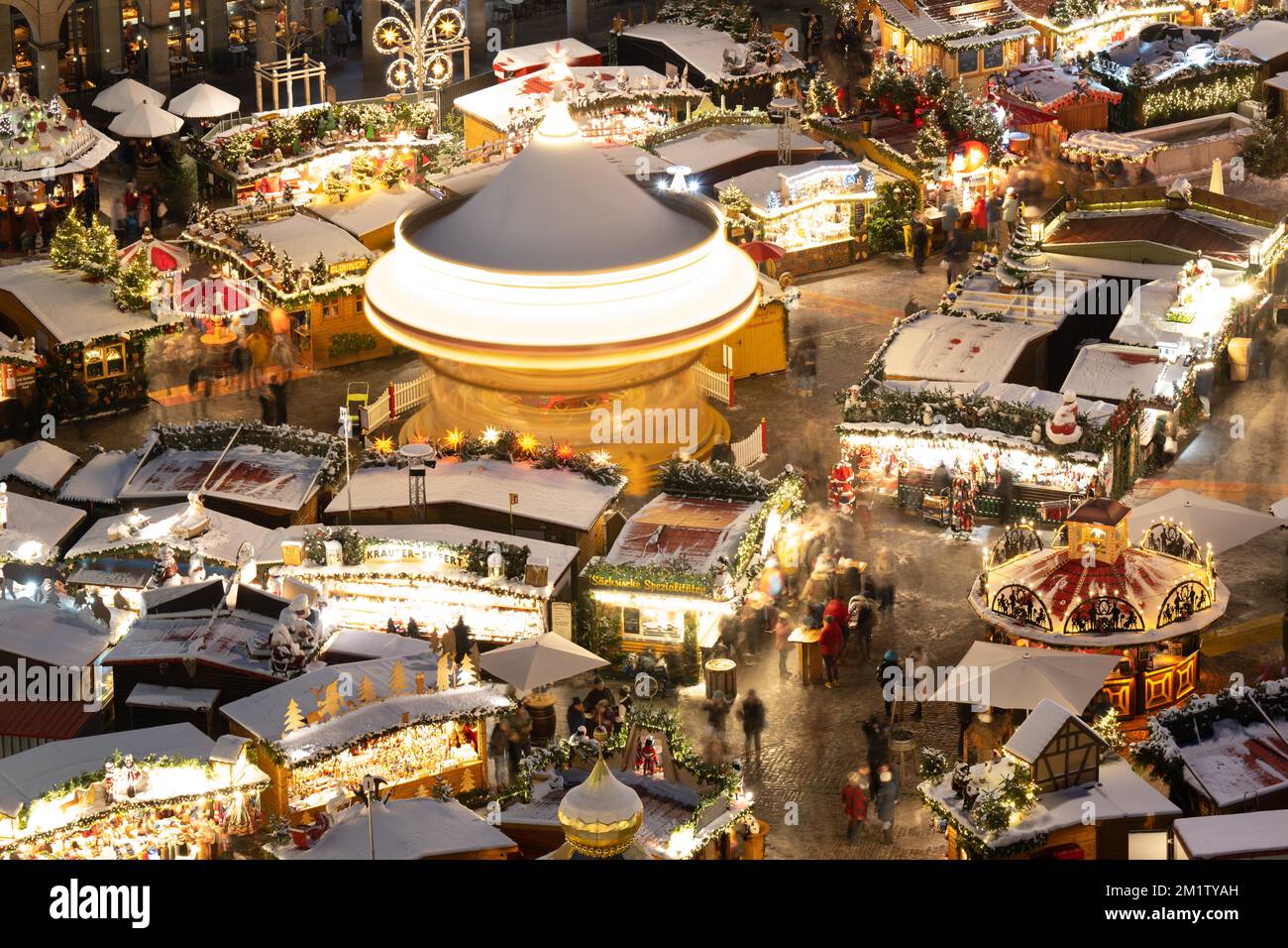 Dresden, Germany. 13th Dec, 2022. A carousel turns next to snow-covered ...