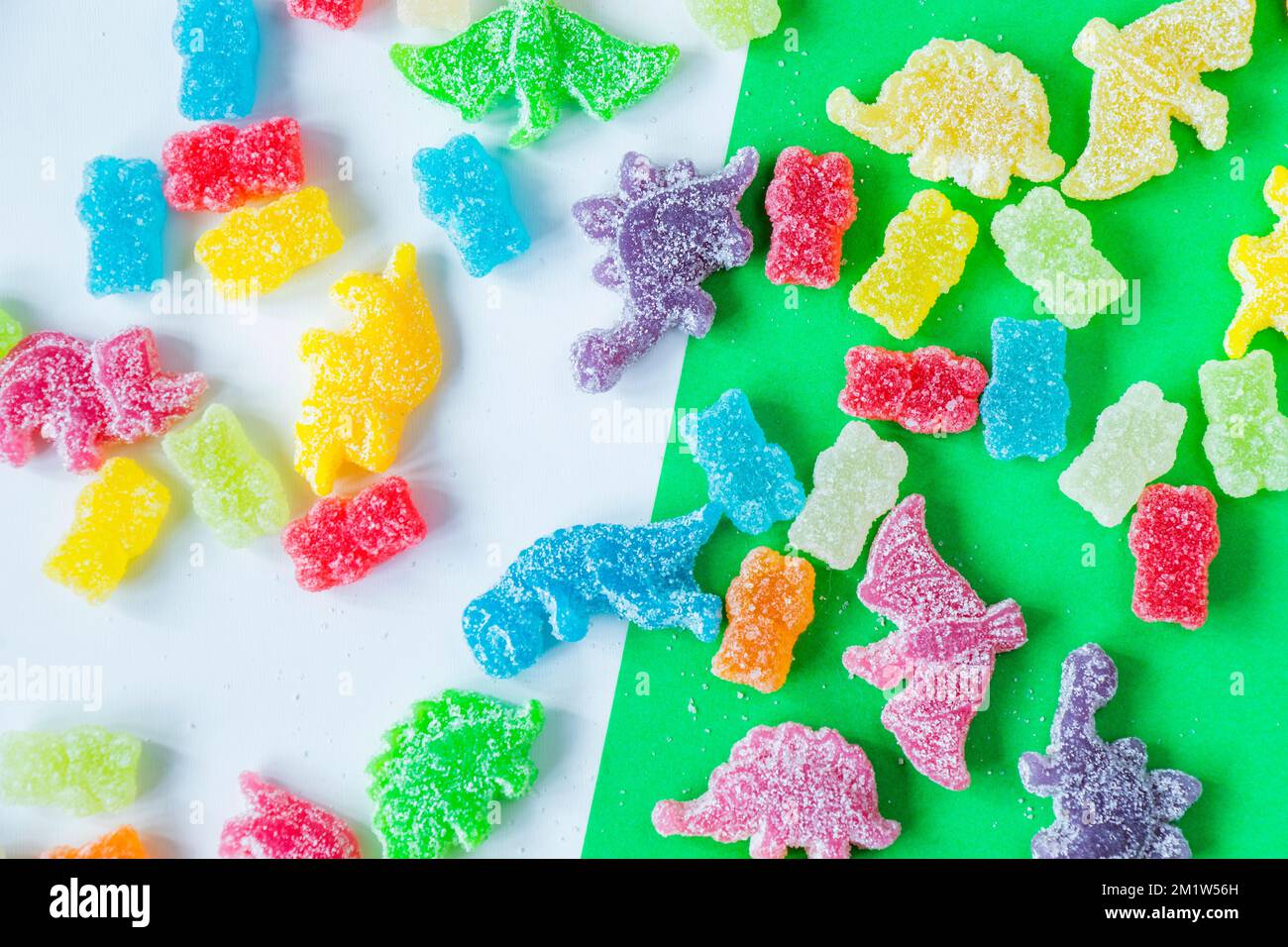 A flat lay of colorful gummy candies in the shape of a dinosaur and a ...