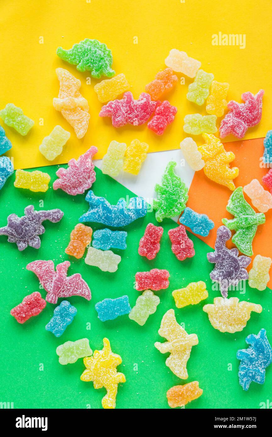 A vertical flat lay shot of colorful gummy candies in the shape of a ...