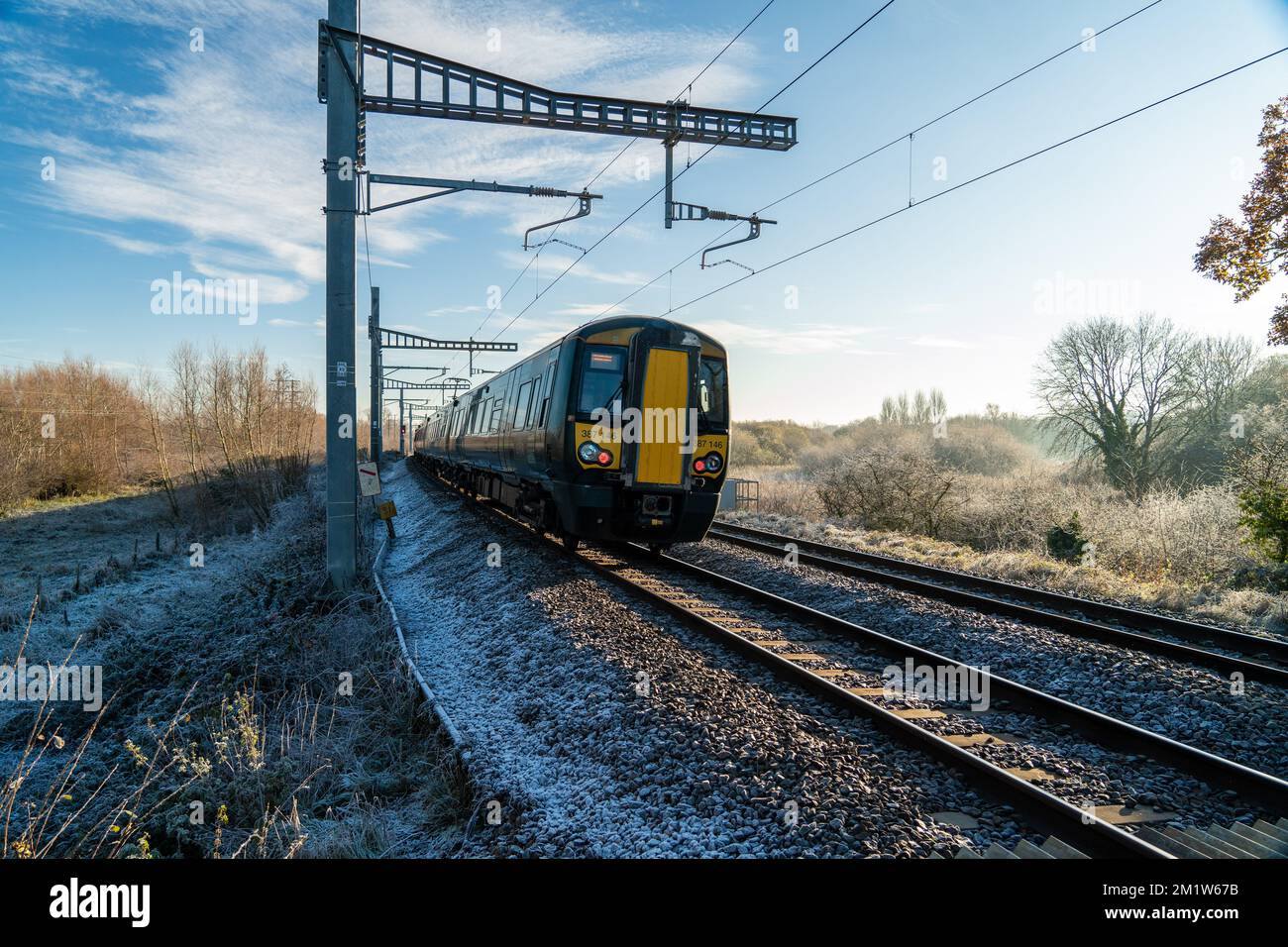 An electric GWR train on a frozen frosty track travelling to London ...