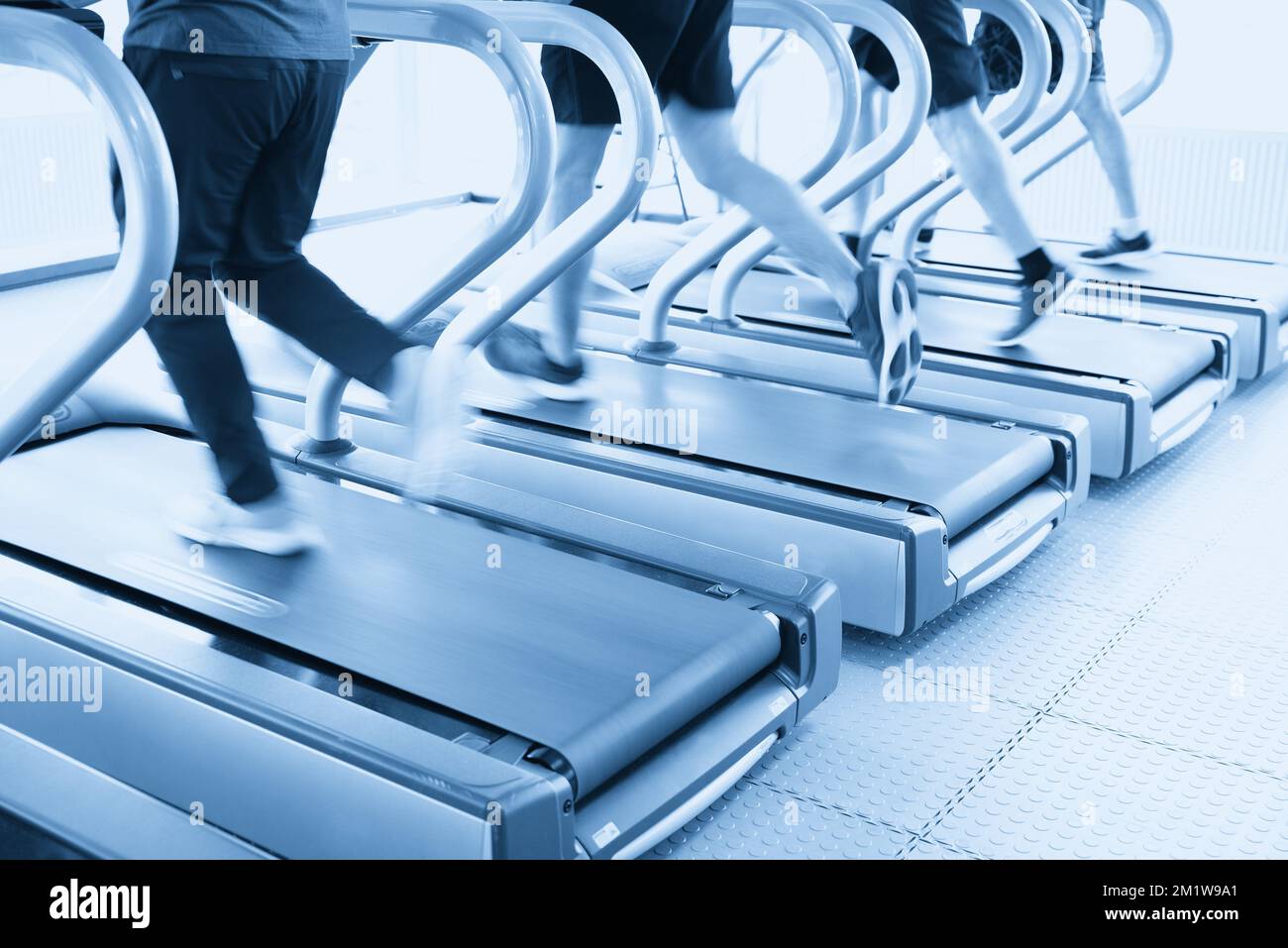 people running on machines, treadmill with motion blur, blue tone Stock ...