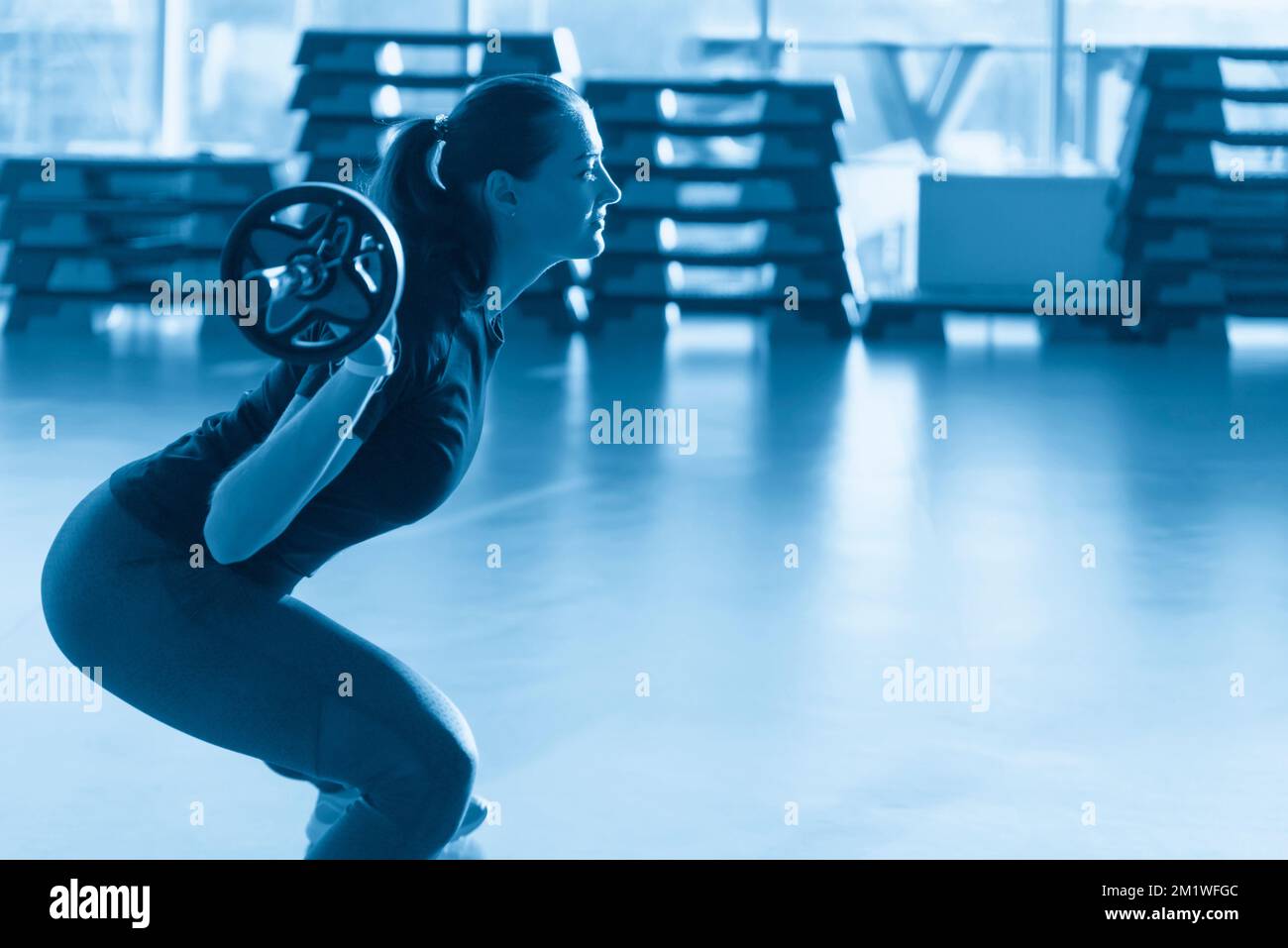 Strong woman weightlifting at the gym looking happy Stock Photo - Alamy