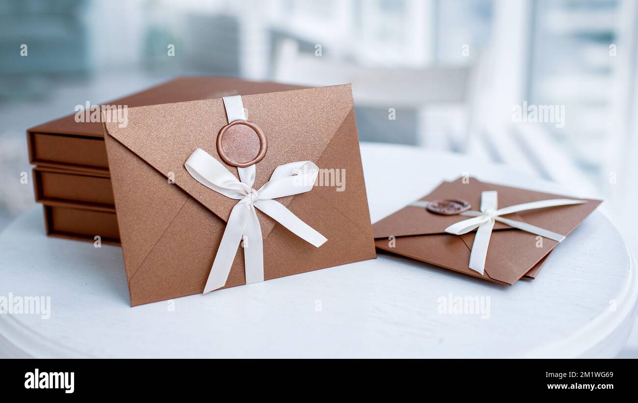bronze envelope with wax seal and bow as wedding invitation card on ...