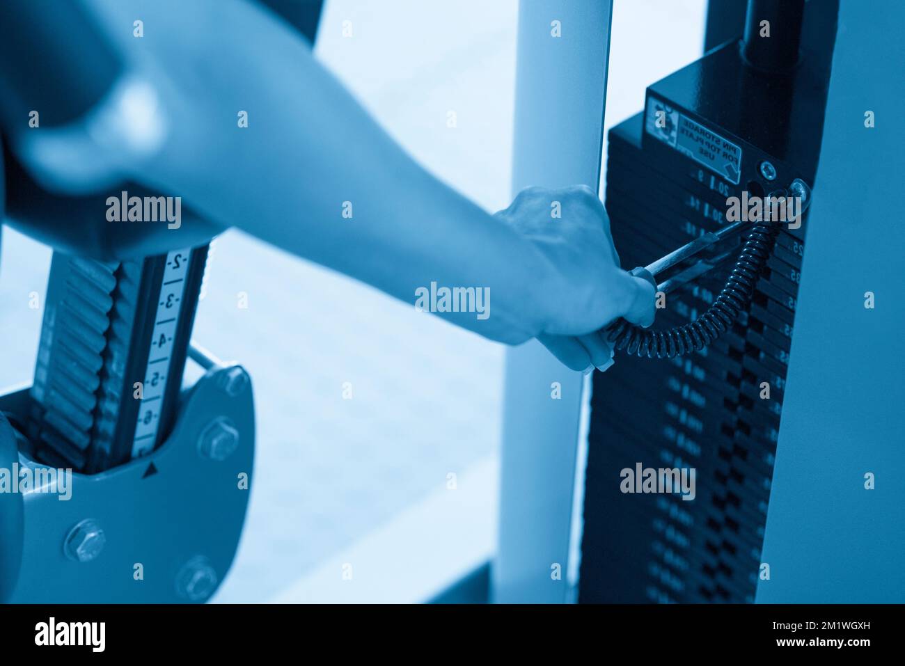 Weight adjustment on training equipment at a gym. Separating weight for ...