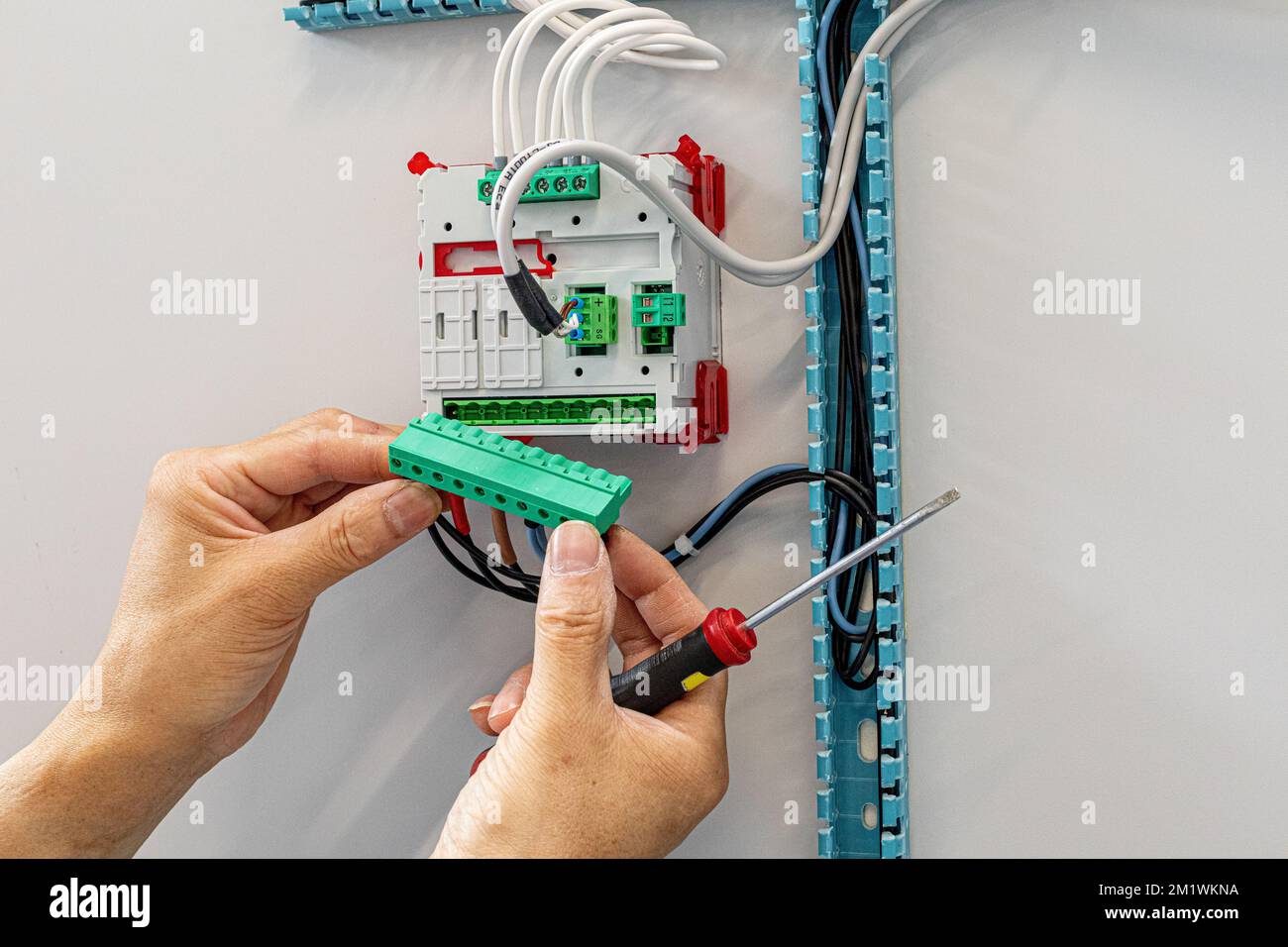 A closeup of a worker's hands connecting wires of terminal block Stock ...