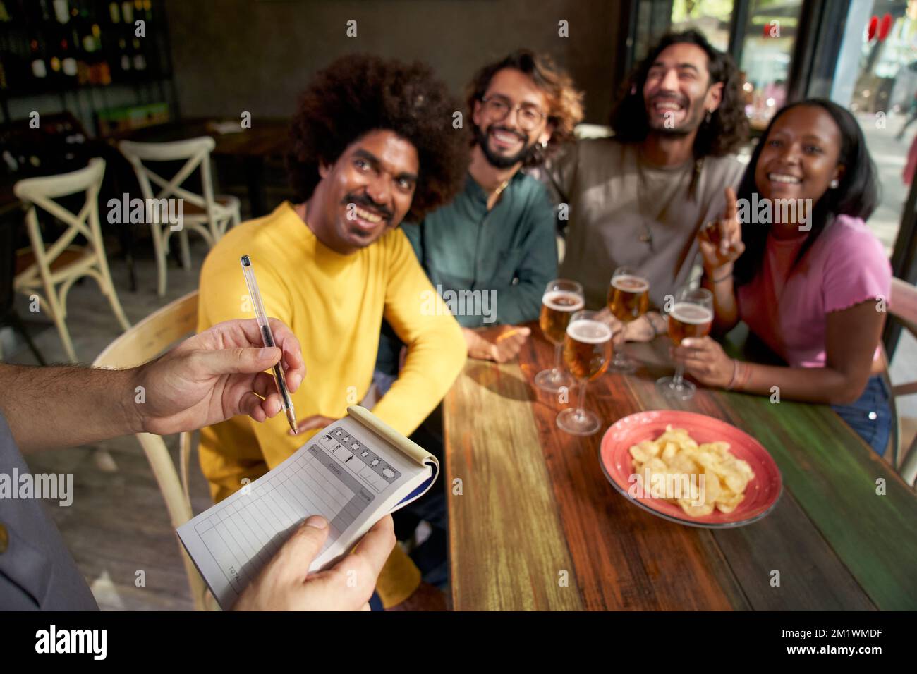 Close-up of the hands of a waiter taking note of the order. The group ...