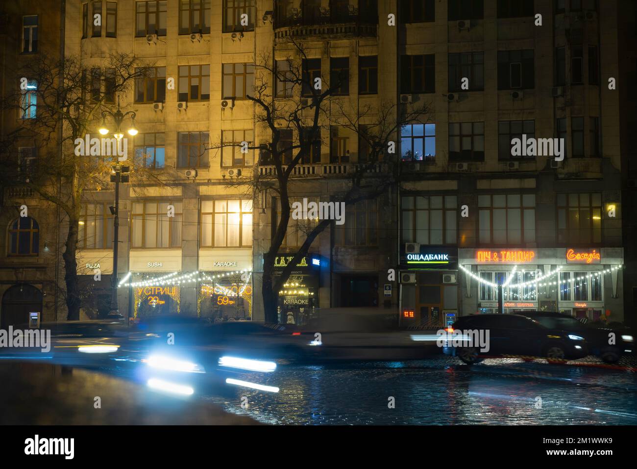 Traffic car lights with residential units and shops at kyiv night Stock ...