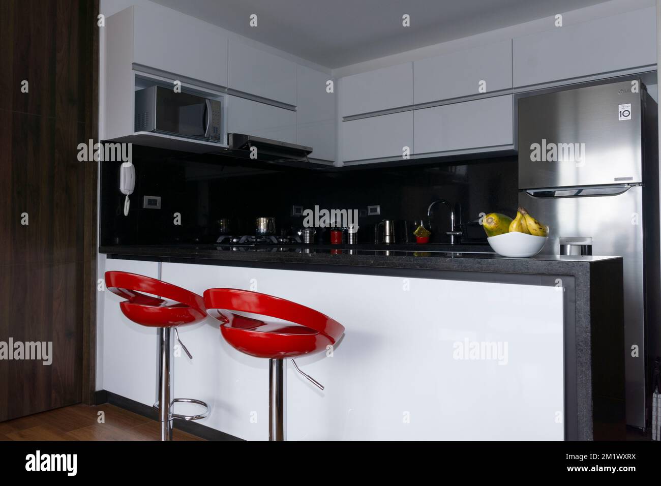 Modern black and white marble kitchen with silver fridge with natural ...