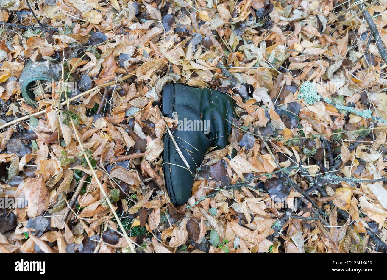 Old military black boot over autumn leaves laying ground on chernobyl ...