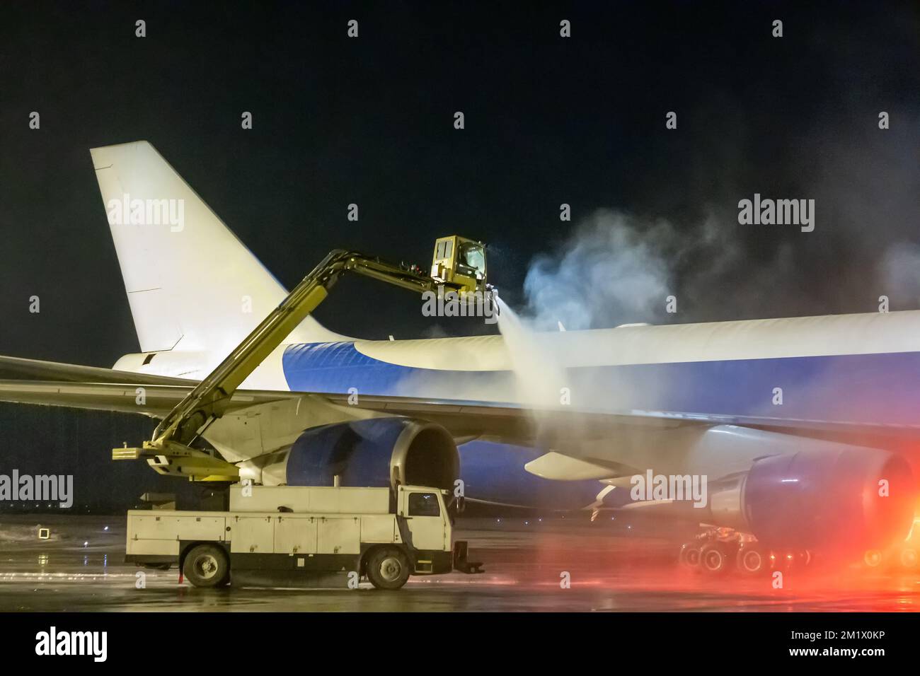 Ground deicing of a big cargo airplane on the night airport apron Stock ...