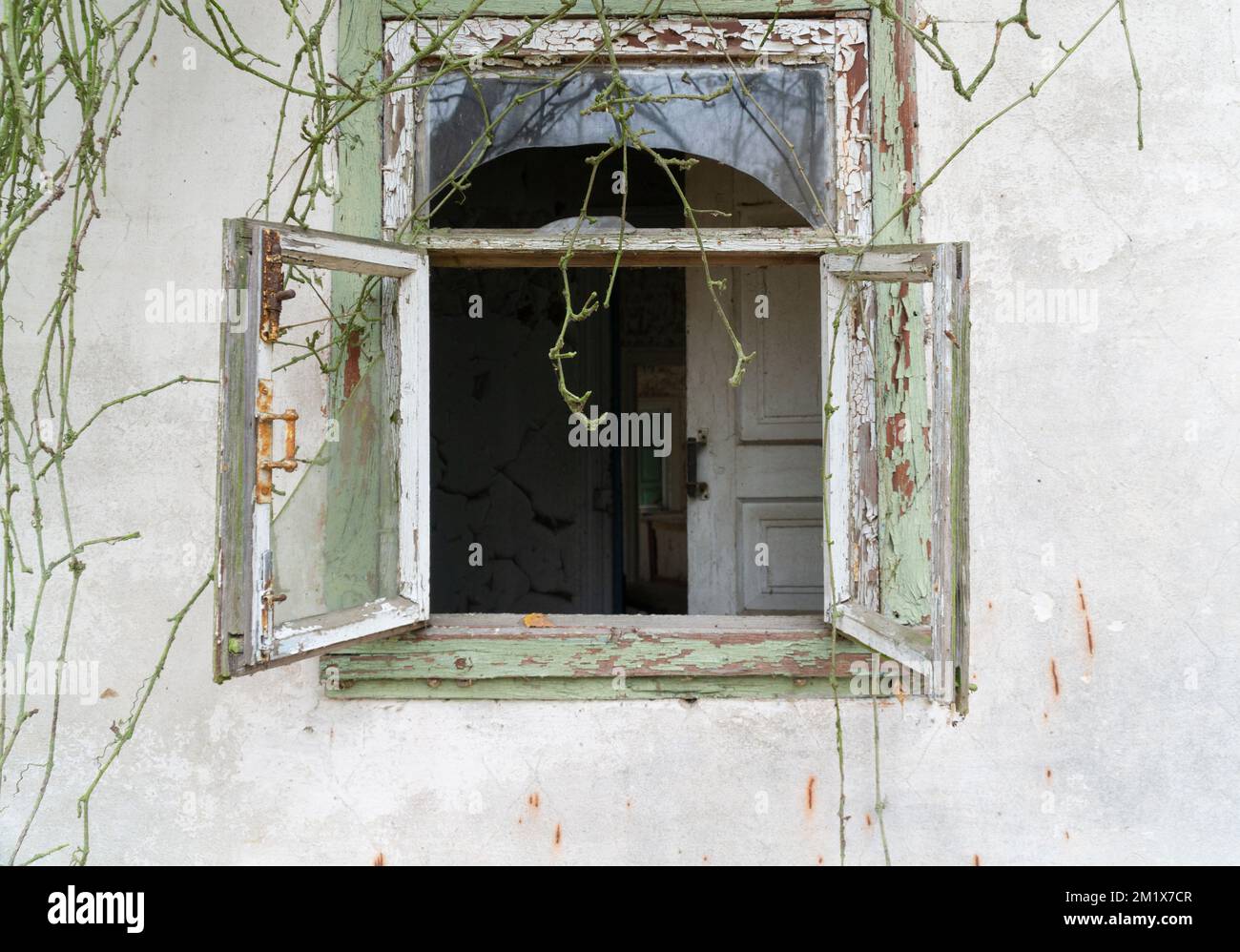an old and rusty open window with broken glass in middle of a chernobyl ...