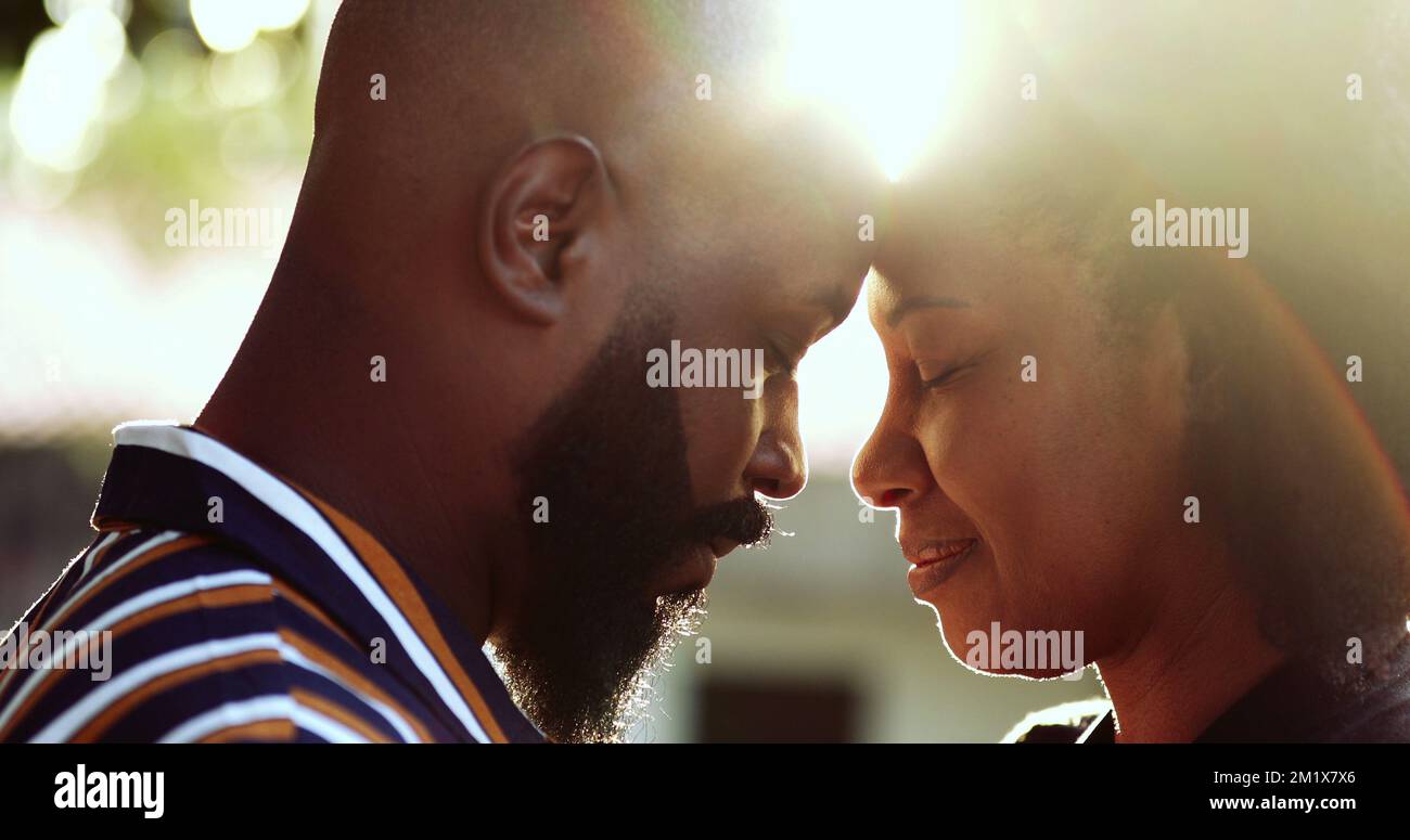 African couple in love eyes closed leaning on foreheads together ...