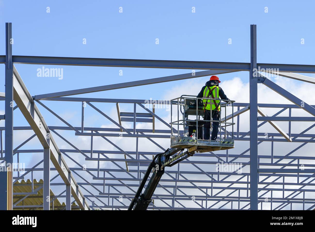 Worker in self propelled articulating boom lift basket in uniform and ...