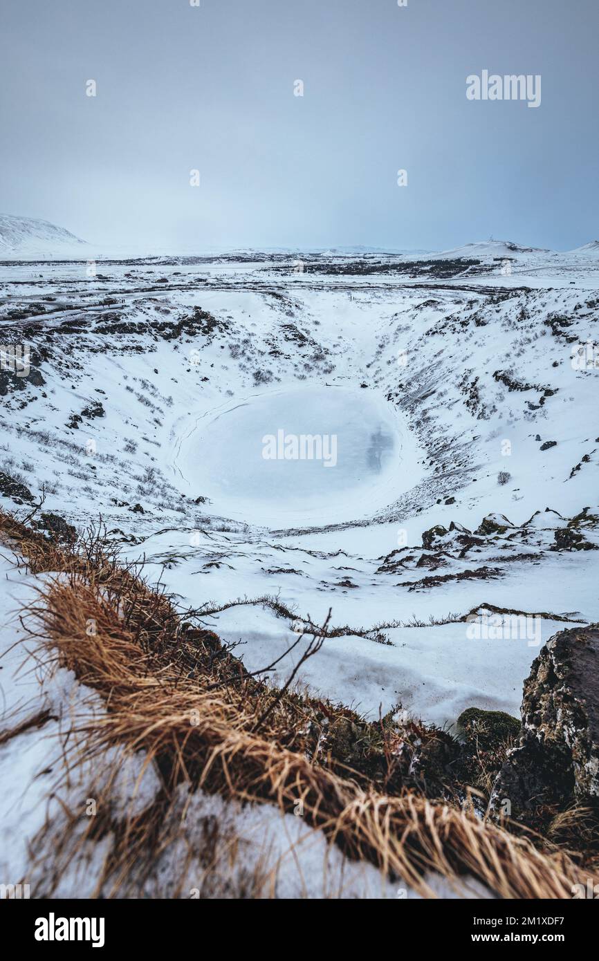 A vertical shot of a frozen lake in winter in a mountainous landscape ...