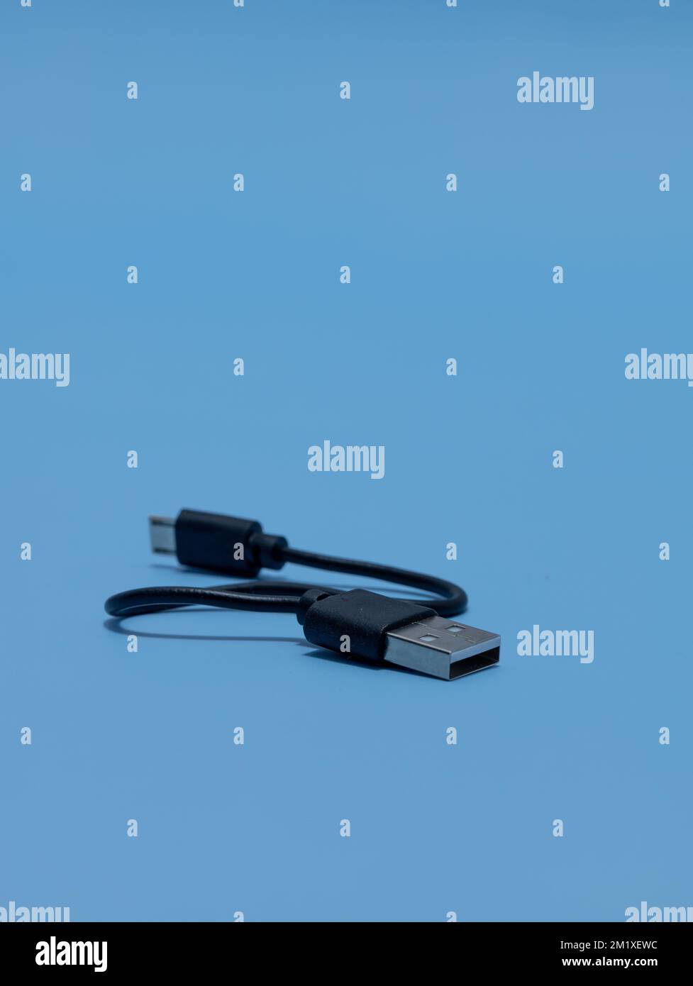 A vertical shot of type A to Micro USB cable on a blue background Stock ...