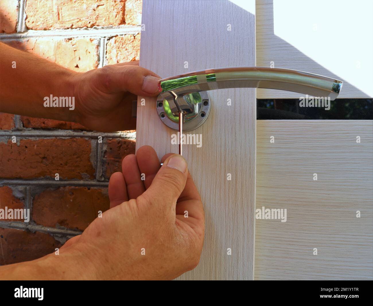 screwing bolts in the structure of the door handle on a light canvas by ...