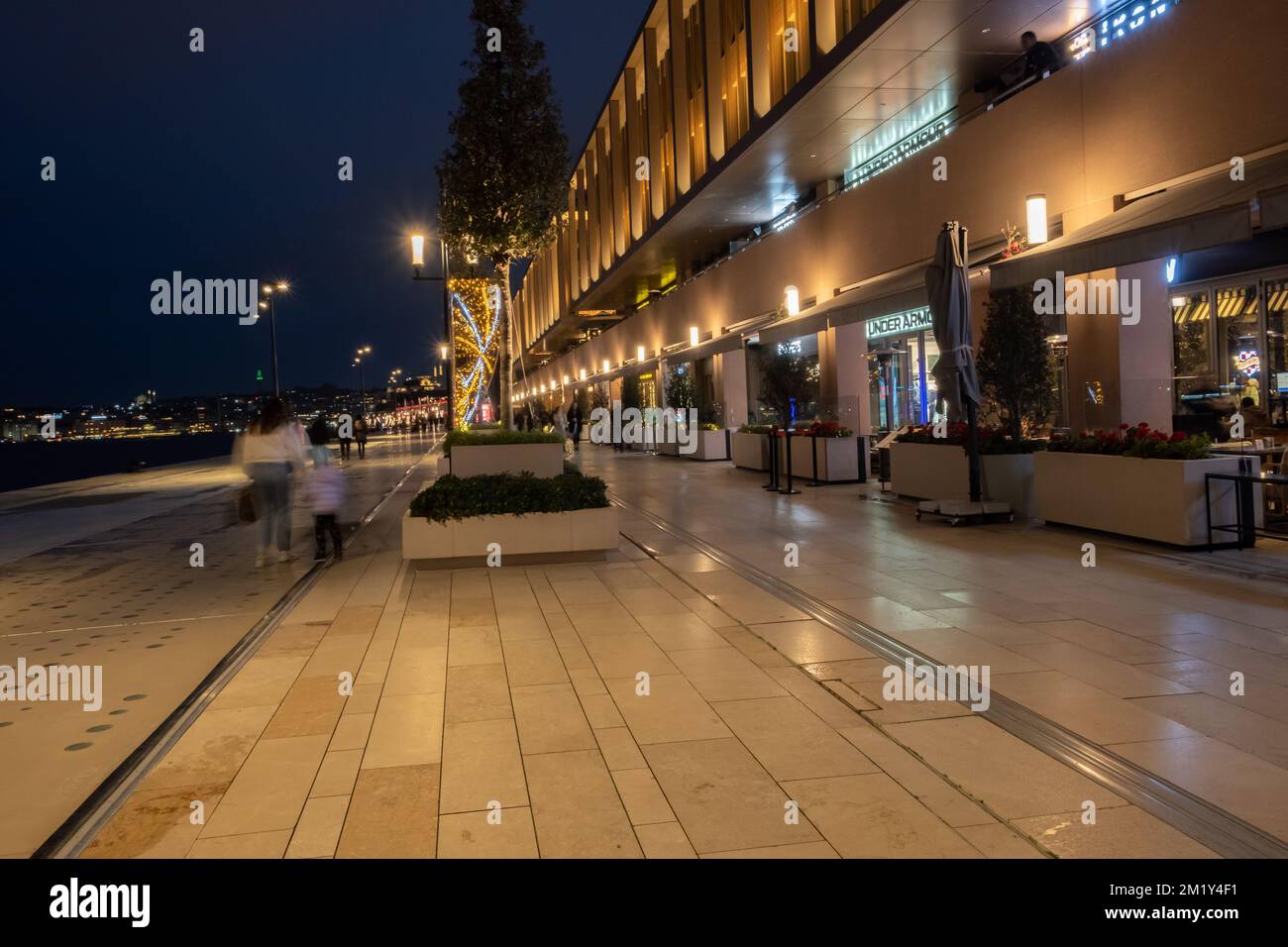 A wall is covered with christmas decorations. Walking path in front of ...