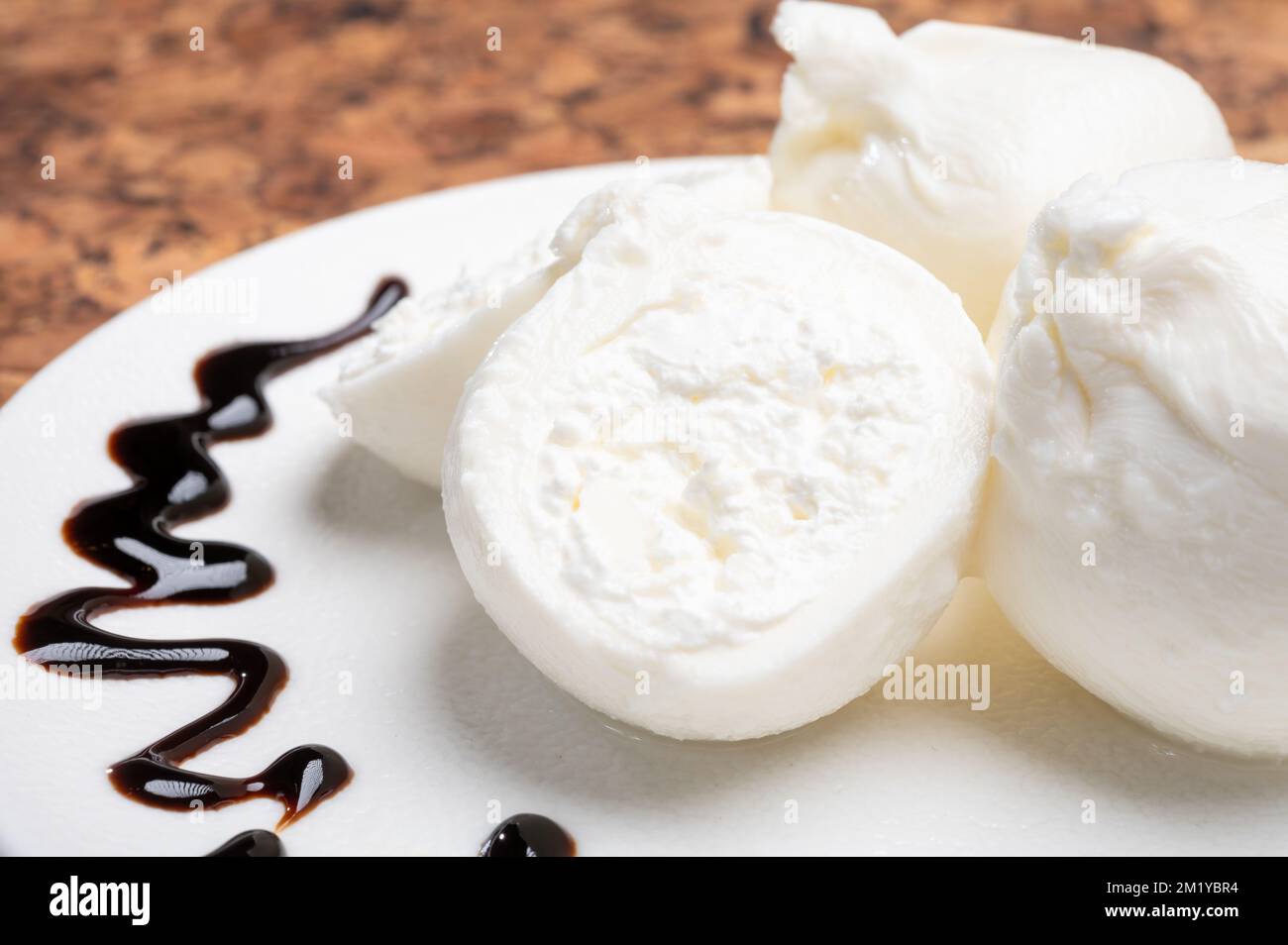 Eating of fresh handmade soft Italian cheese from Puglia, white balls ...