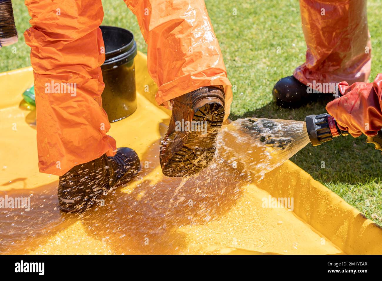 Chemicals being washed off the bottom of industrial work boots by water ...