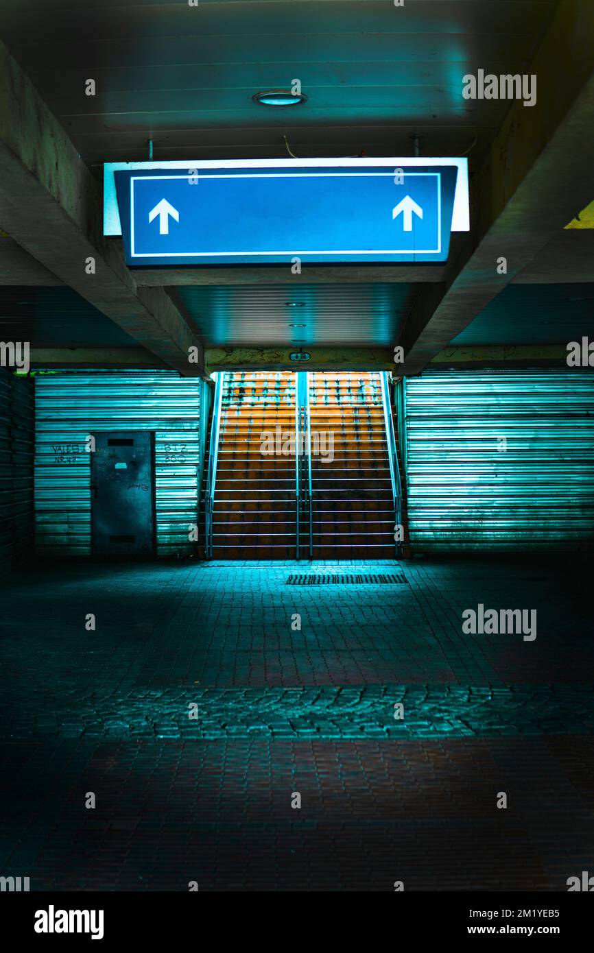 A vertical shot of an empty underground crossing with directional signs ...