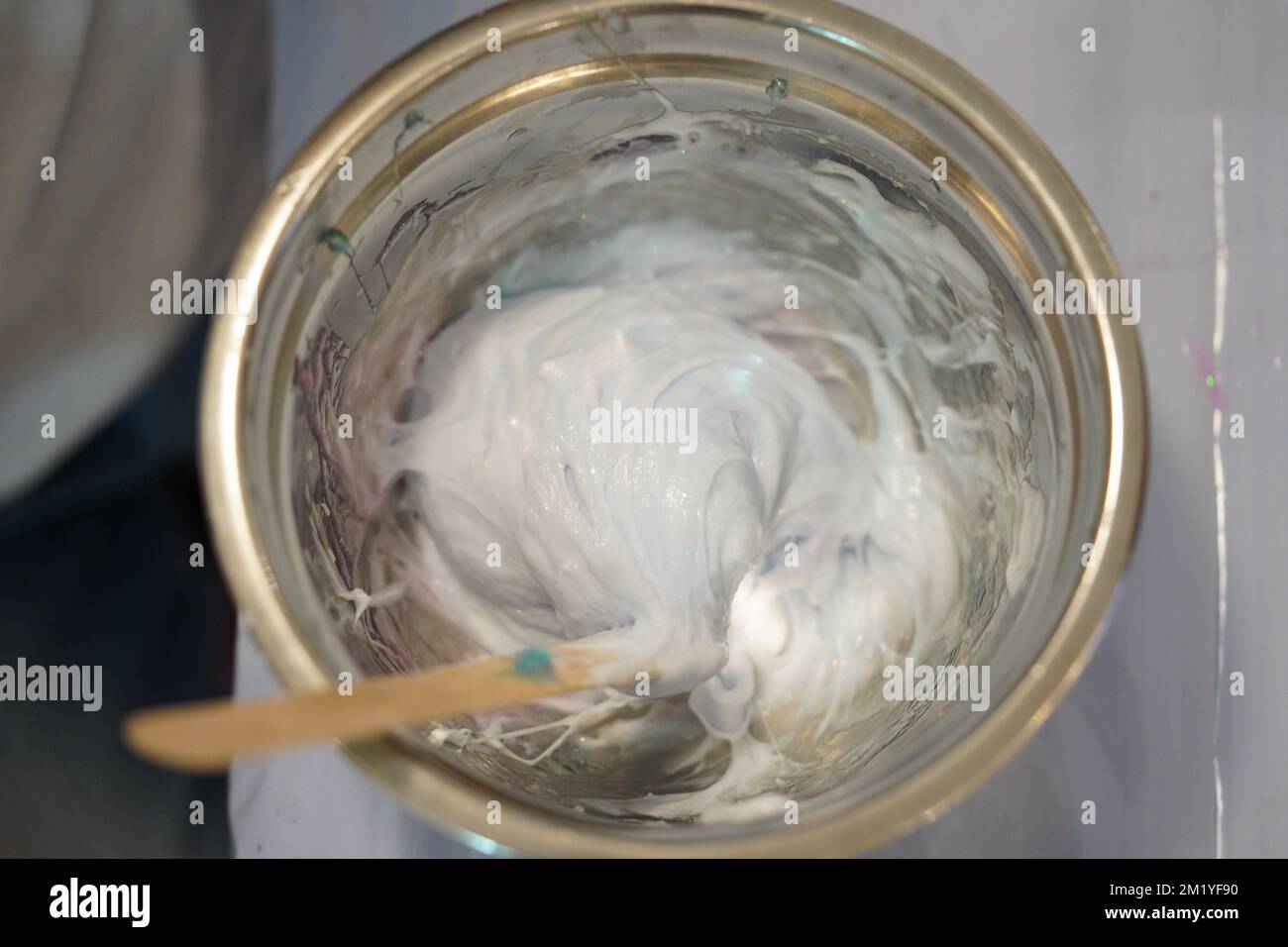 kid making slime adding glitter glue and white glue mixing it with ...