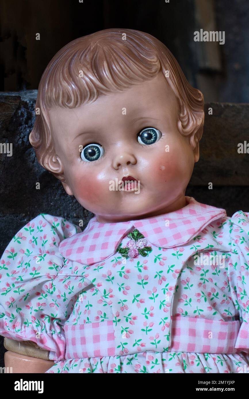 Face of antique doll with blue eyes and rosy cheeks, wearing a white ...