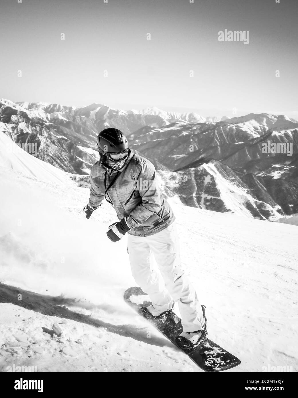 Young snowboarder ride downhill in scenic caucasus mountains in fast ...
