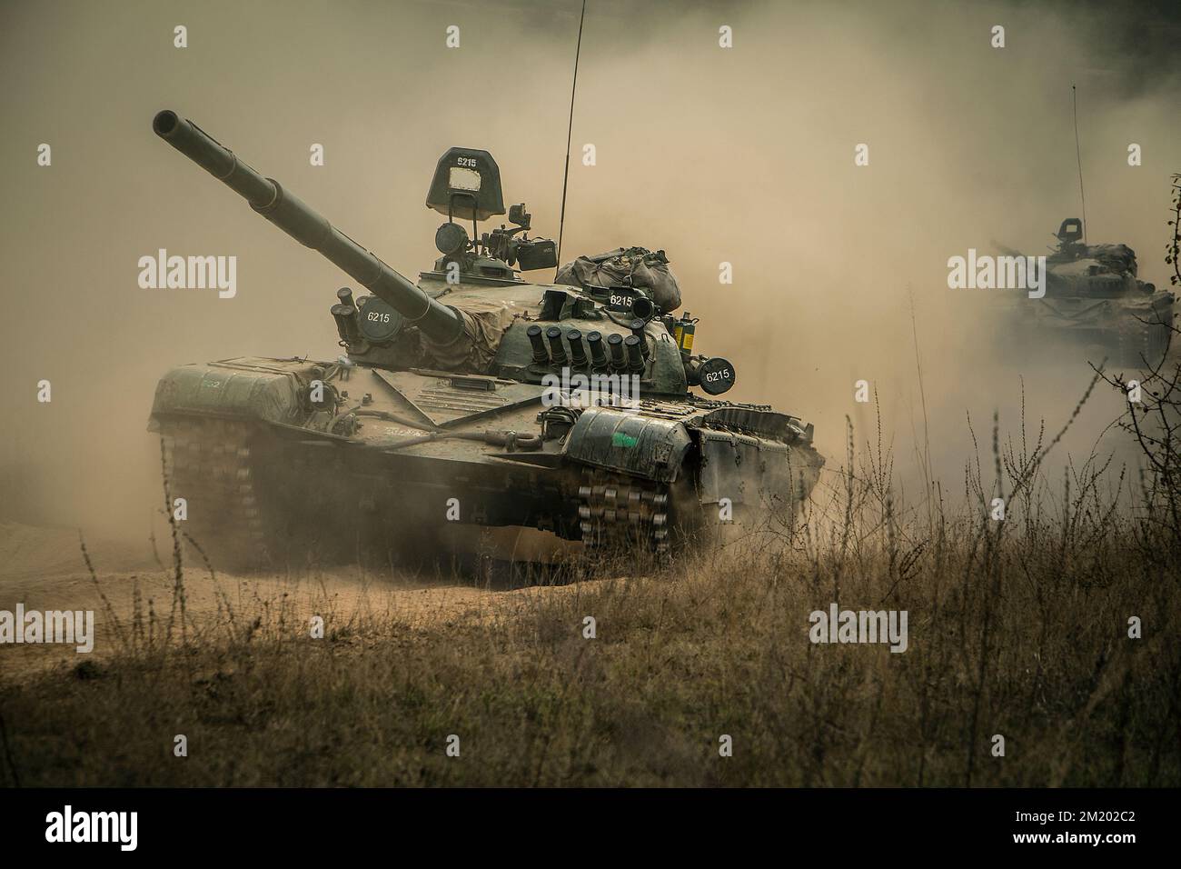 The battle tanks in a green field, moving through smoke and dust Stock ...
