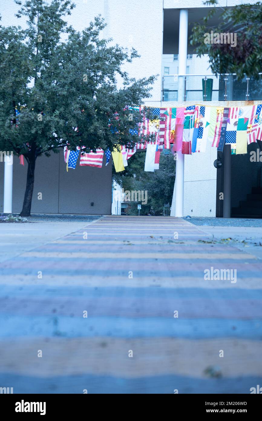 A vertical shot of an opened gate, stone pavements and colorful flags ...