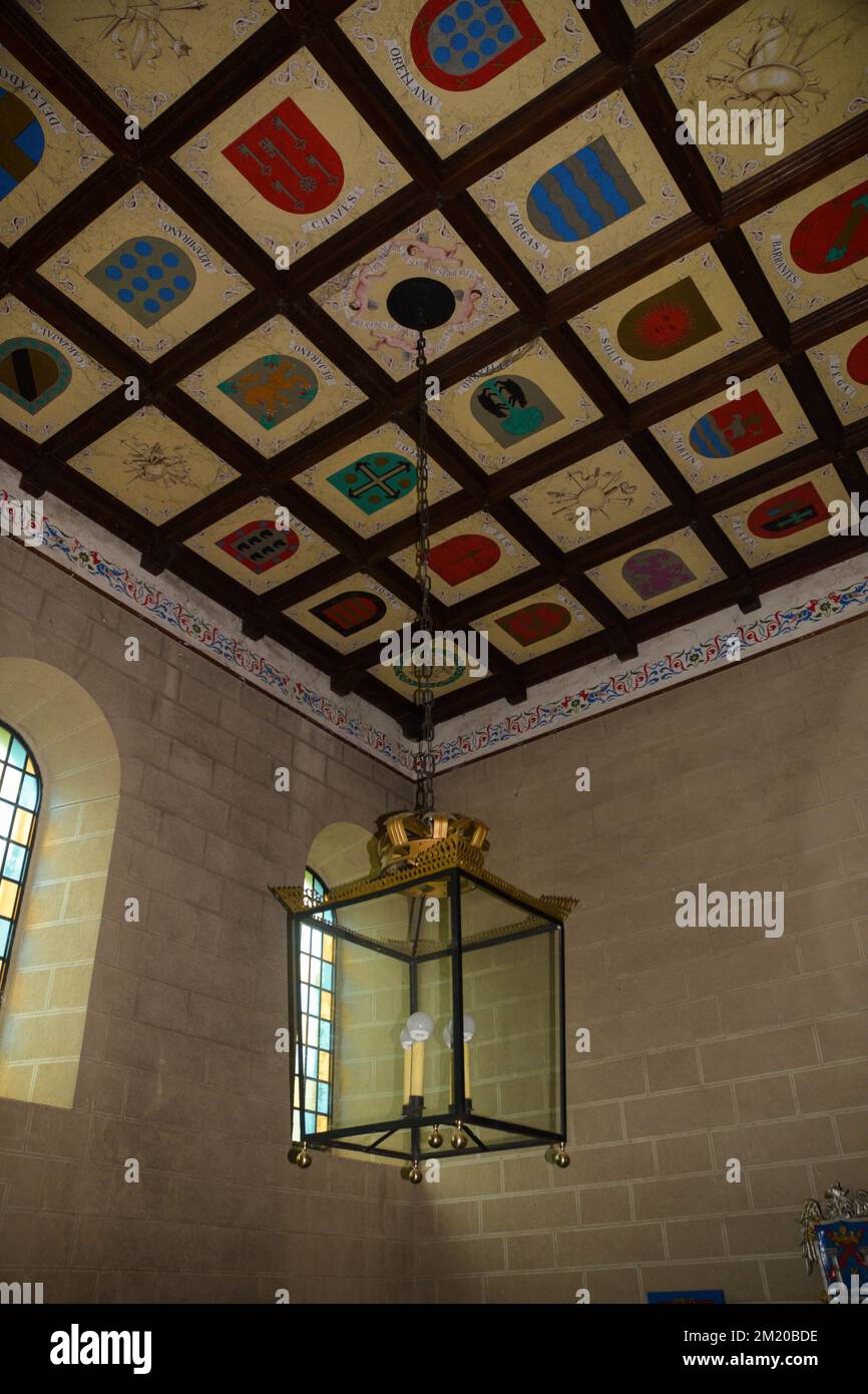 Ceiling decorated with heraldic shields and an old lamp hanging in the ...