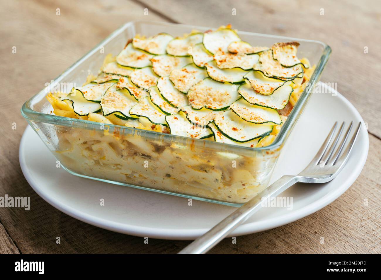 Baking dish with a pasta gratin using spicy tofu pieces and zucchini ...
