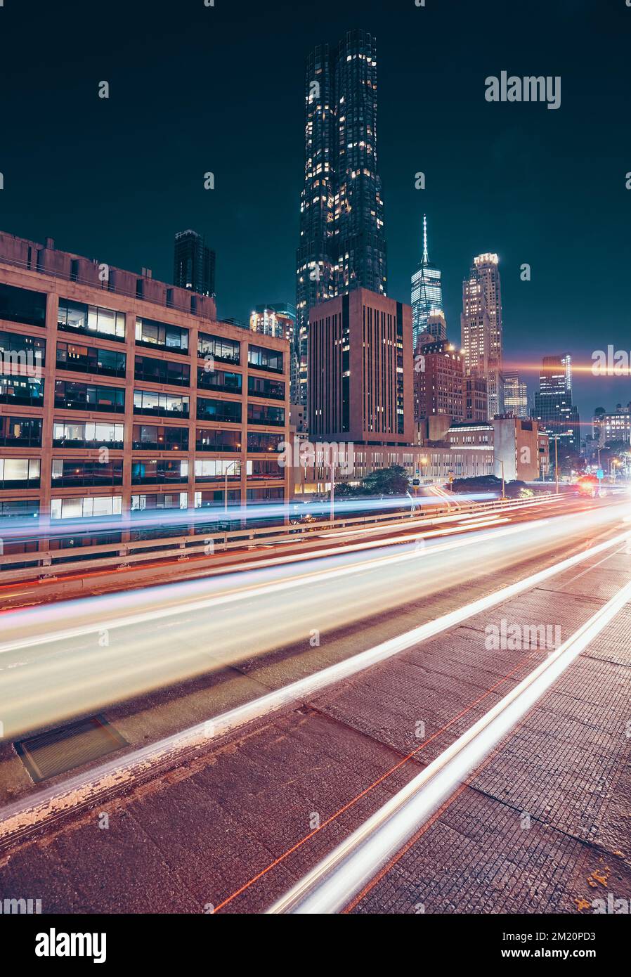 Manhattan cityscape with car light trails at night, color toning ...