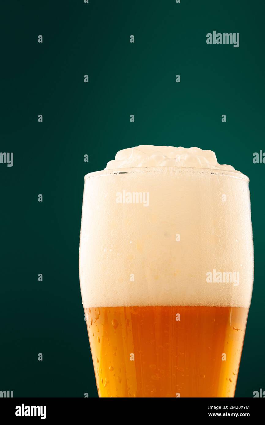 Foam and bubbles in a beer glass close-ups on a green background Stock ...