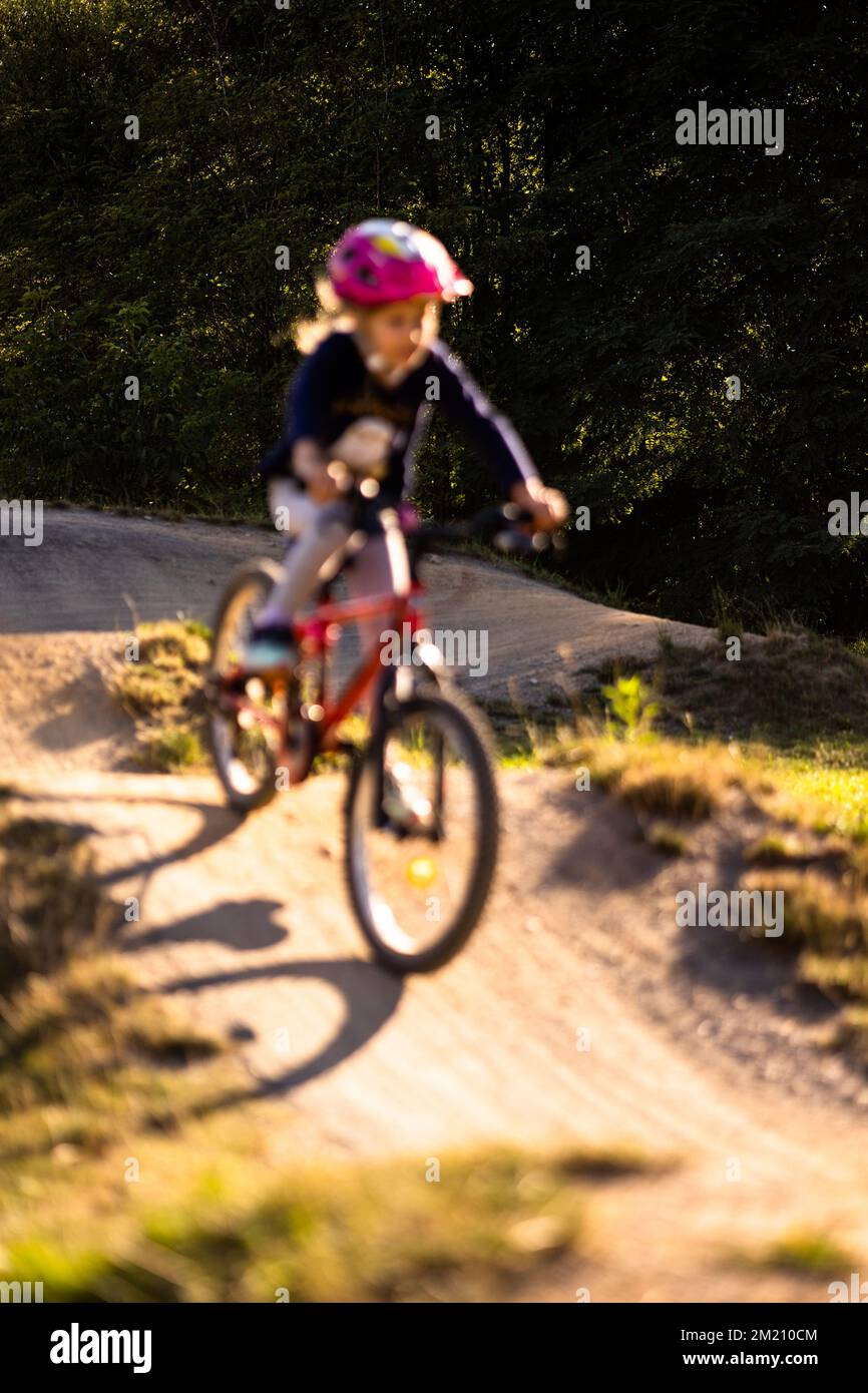 Little girl riding with her bike on a pumptrack Stock Photo - Alamy