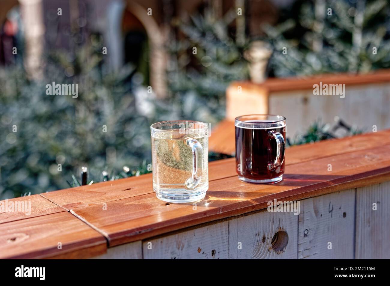 A closeup shot of the cup of coffee and water in the balcony on a sunny ...