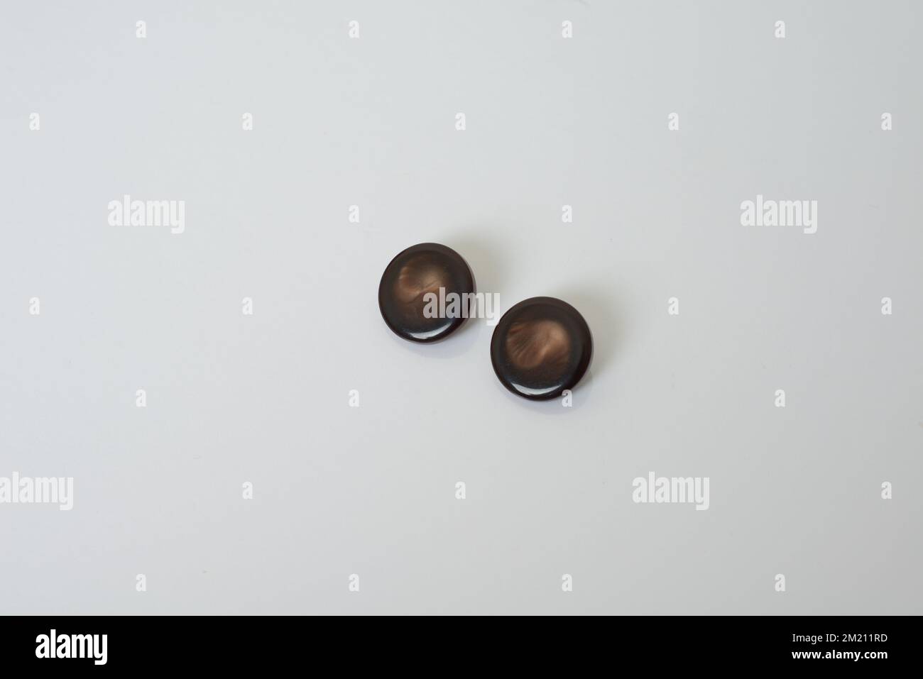 A top view of black vintage plastic buttons for sewing against a white ...