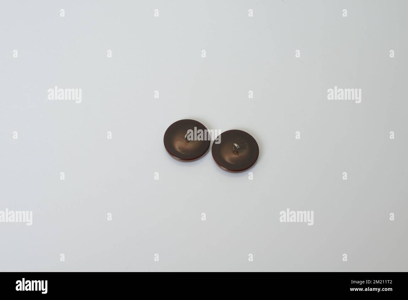 A top view of black vintage plastic buttons for sewing against a white ...