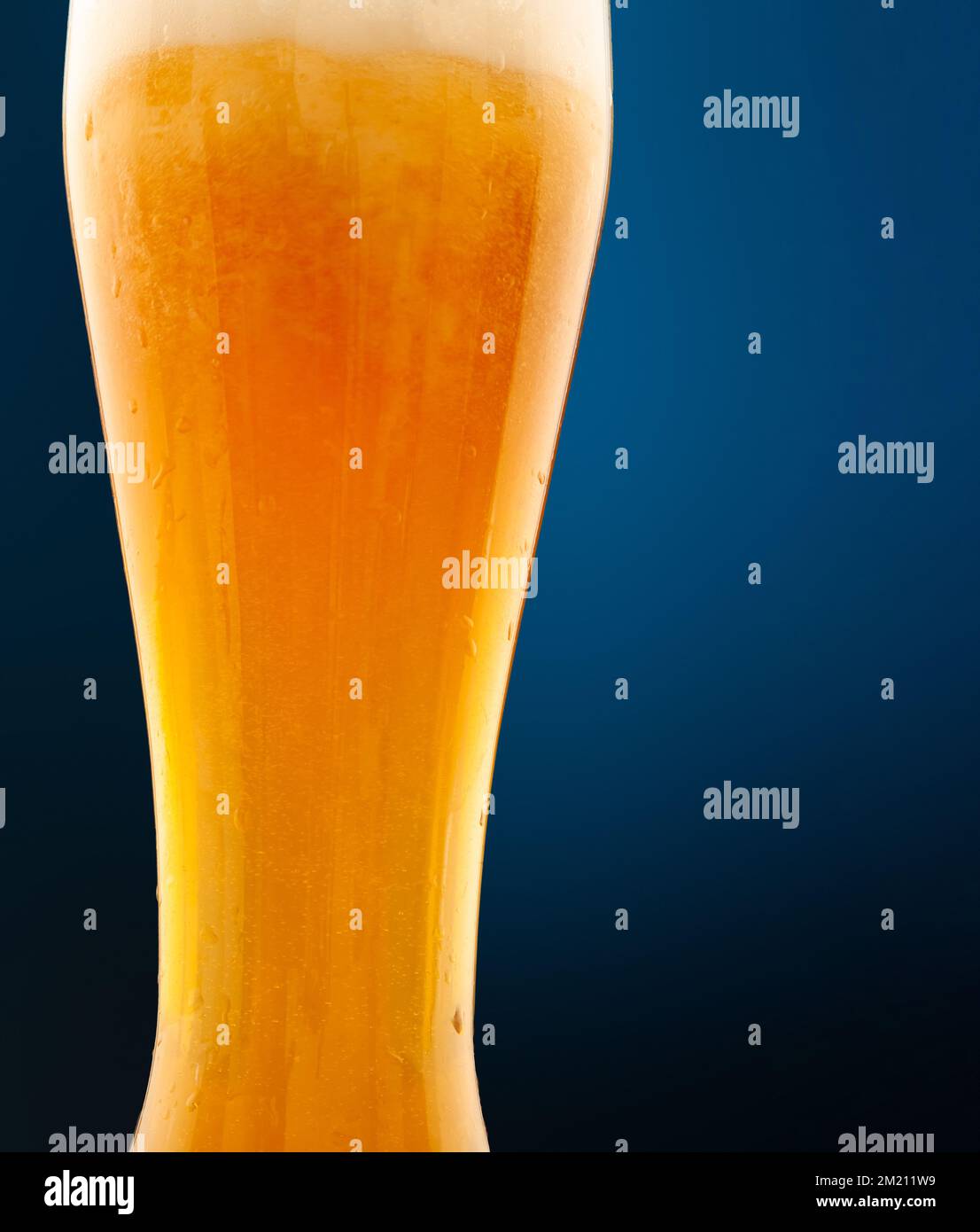 Foam and bubbles in a beer glass close-ups on a blue background Stock ...