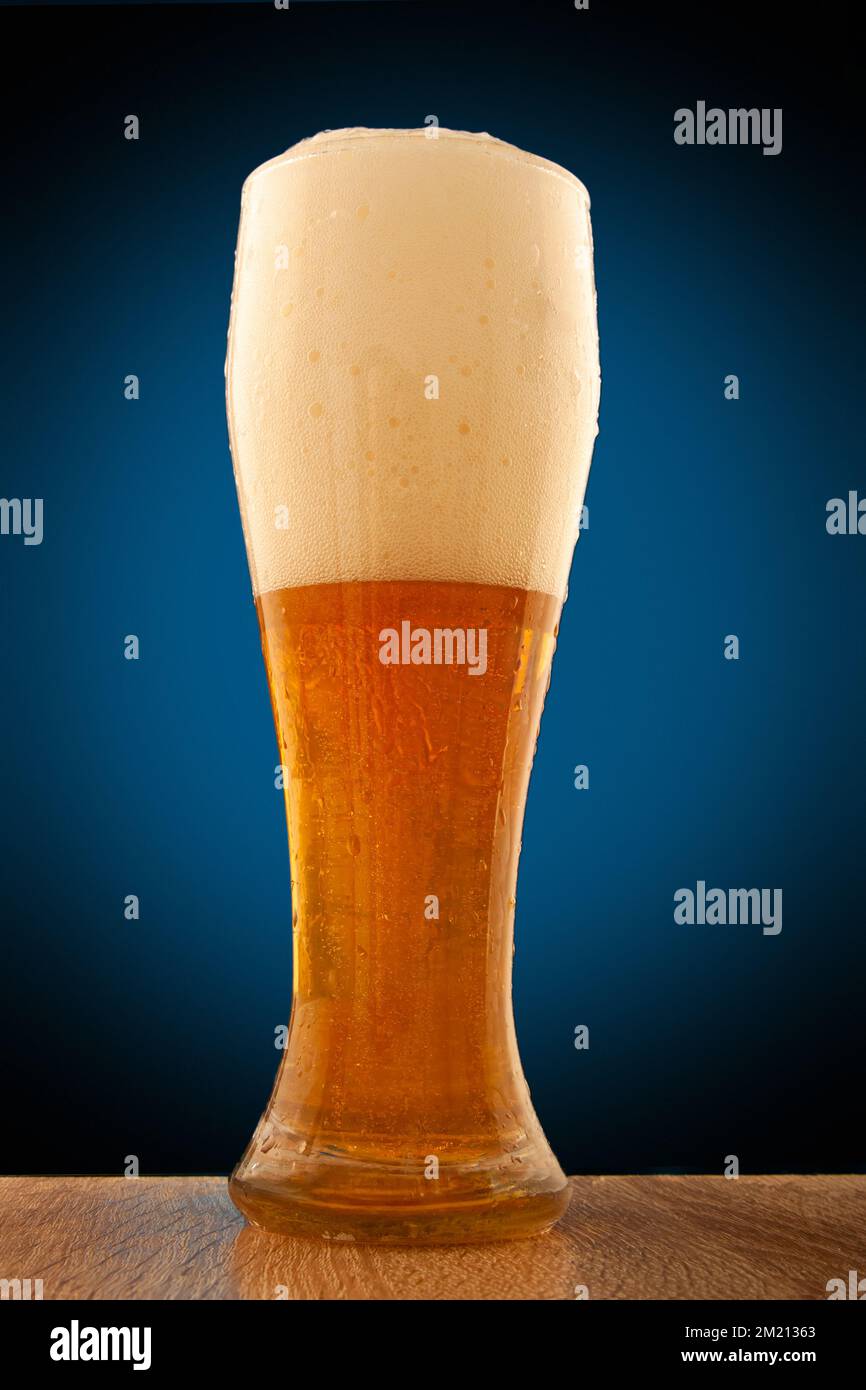 Foam and bubbles in a beer glass close-ups on a blue background Stock ...