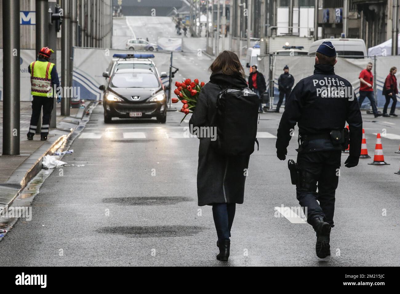 A woman holding flowers, is entering the security perimeter with a ...