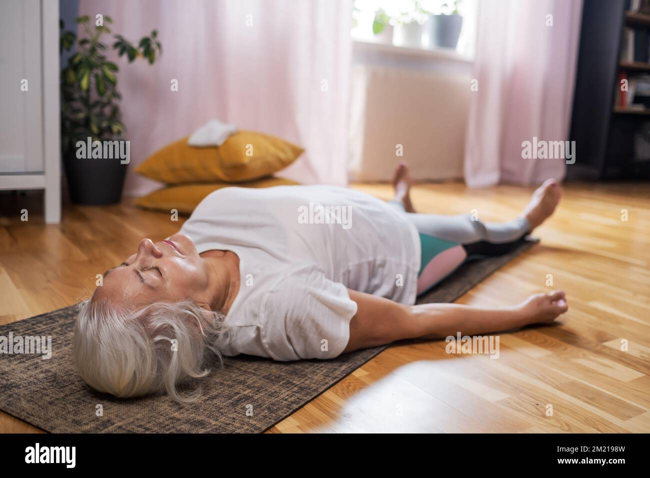 Woman lying on yoga mat after workout. Fit female relaxing on floor at ...