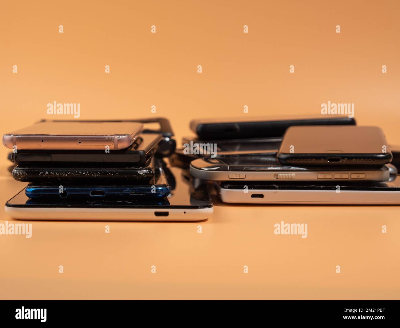 Lots of old smartphones on an orange background. Old mobile phones ...