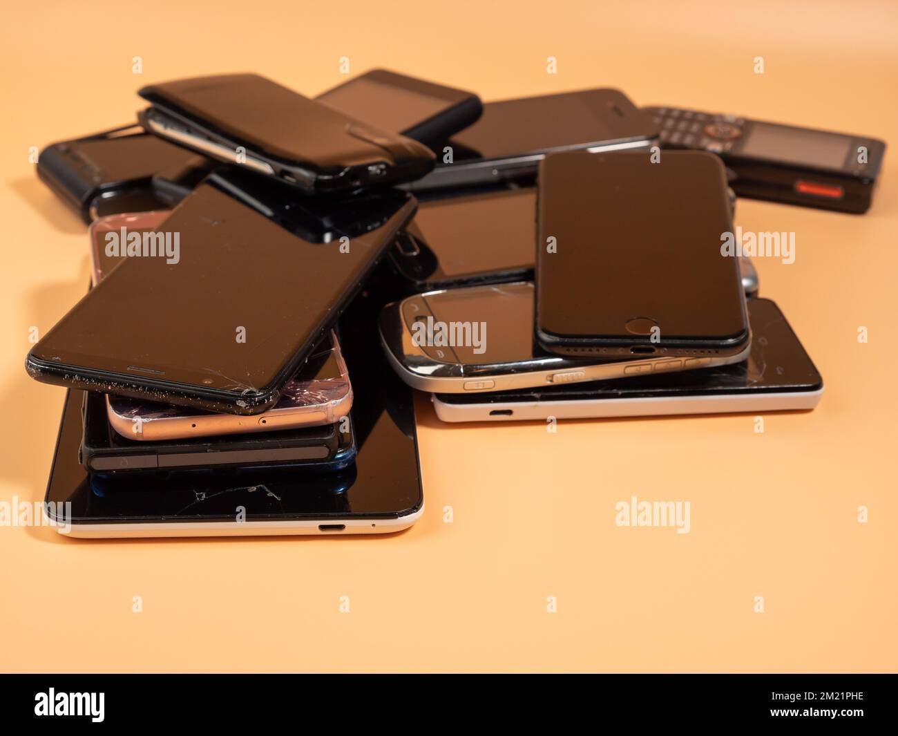 Lots of old smartphones on an orange background. Old mobile phones ...